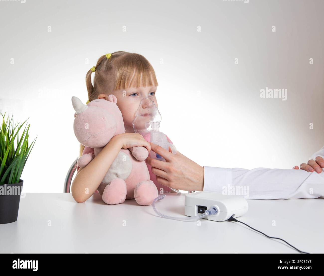 Beautiful little girl breathing into an inhaler for asthma and ...