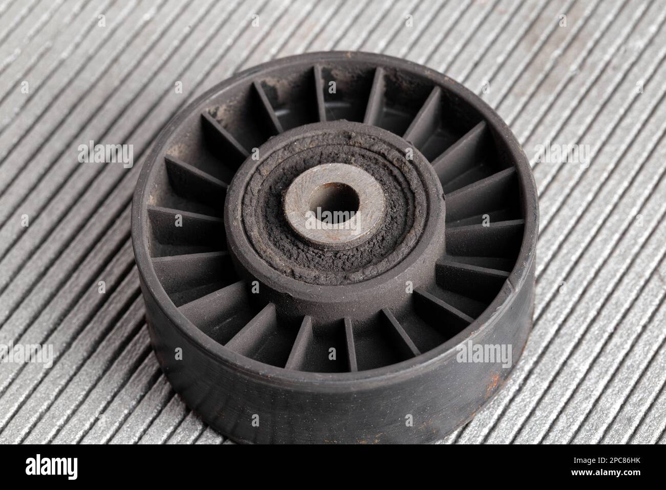 Old dirty car roller made of plastic and bearing on a gray background ...