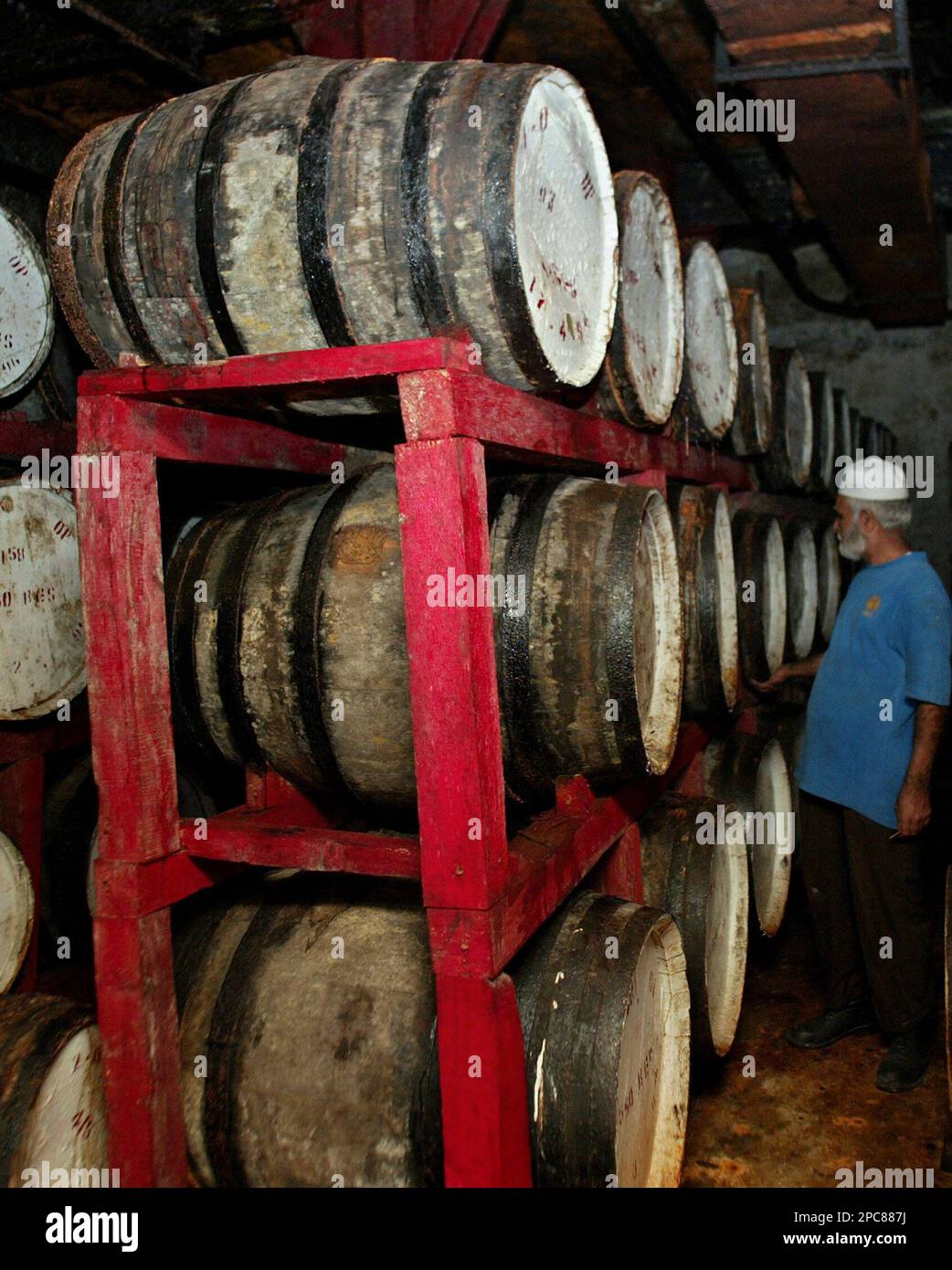 An employee of Pakistan's Murree's Brewery Noor Ellahi examines whiskey ...