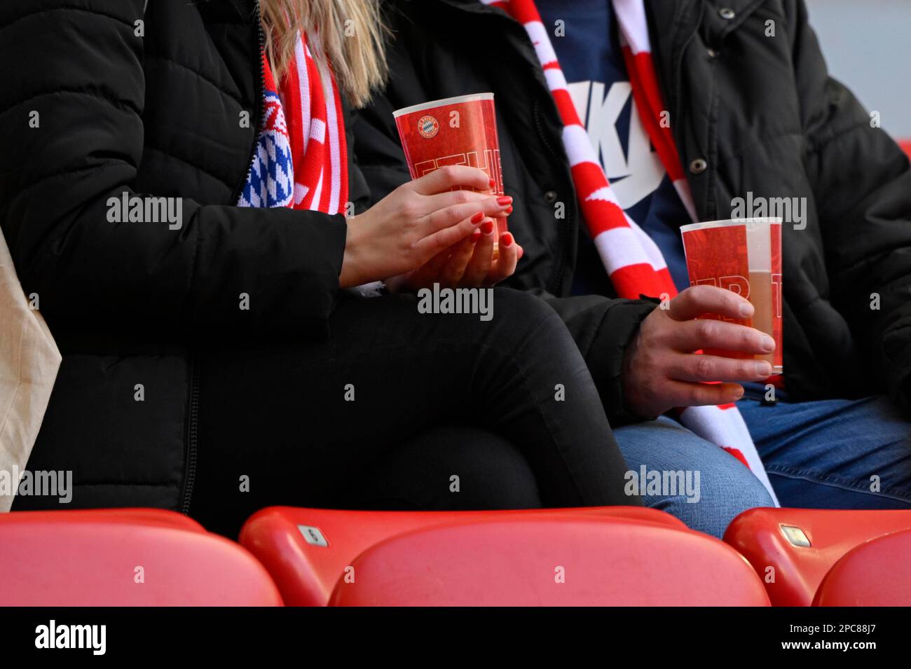 Spectators with FC Bayern Munich FCB scarves and drinking cups, woman ...