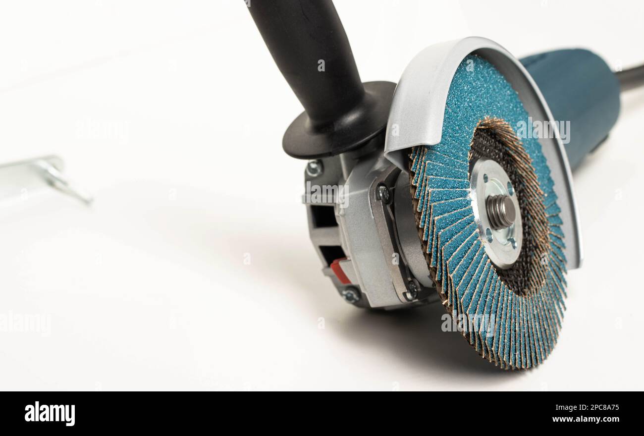 Modern professional angle grinder with a flap wheel on a white ...
