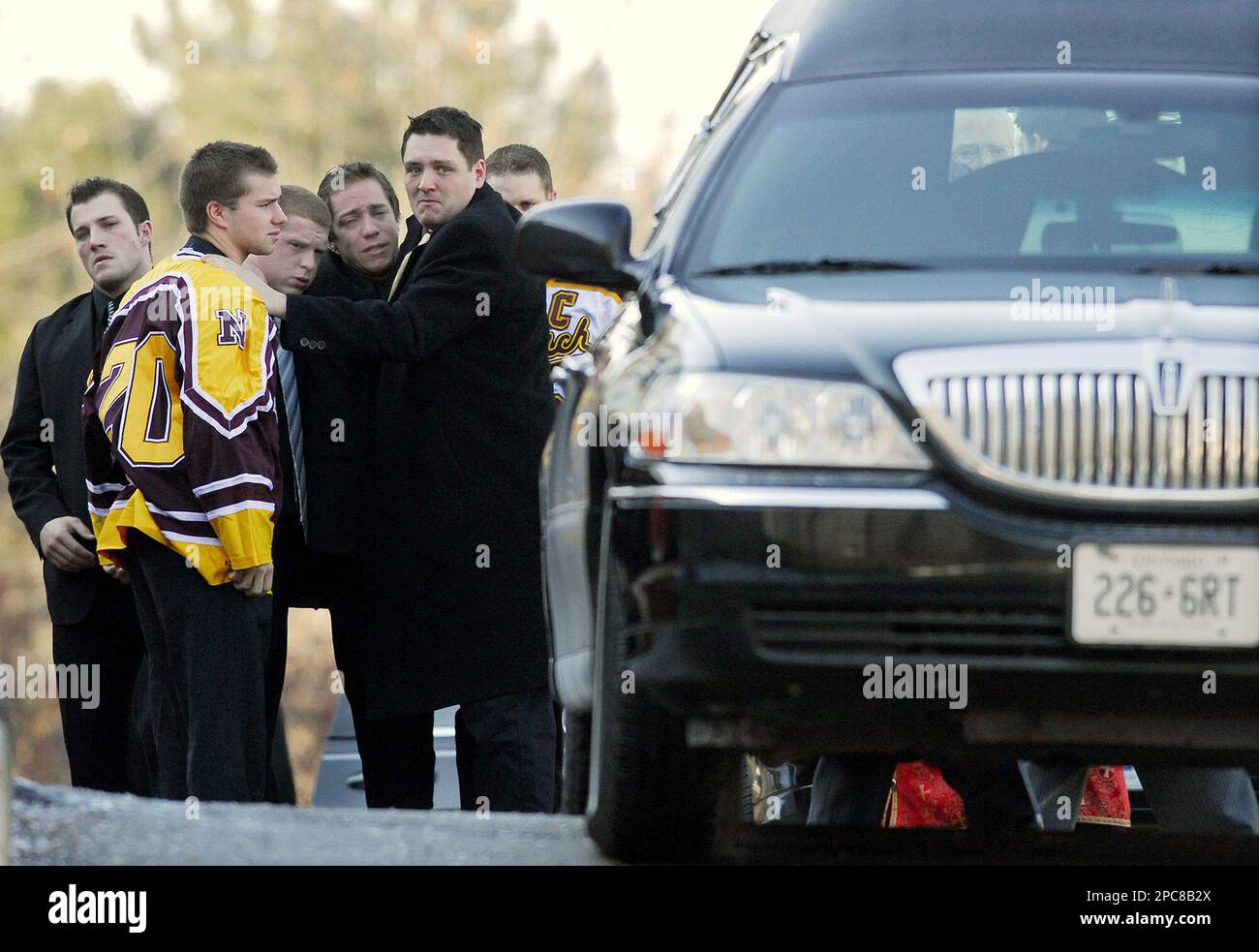 Unidentified men console each other following the funeral of Michael ...