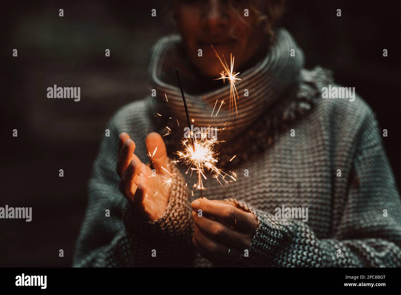 Woman hands close up holding sparkler light to celebrate alone in the ...