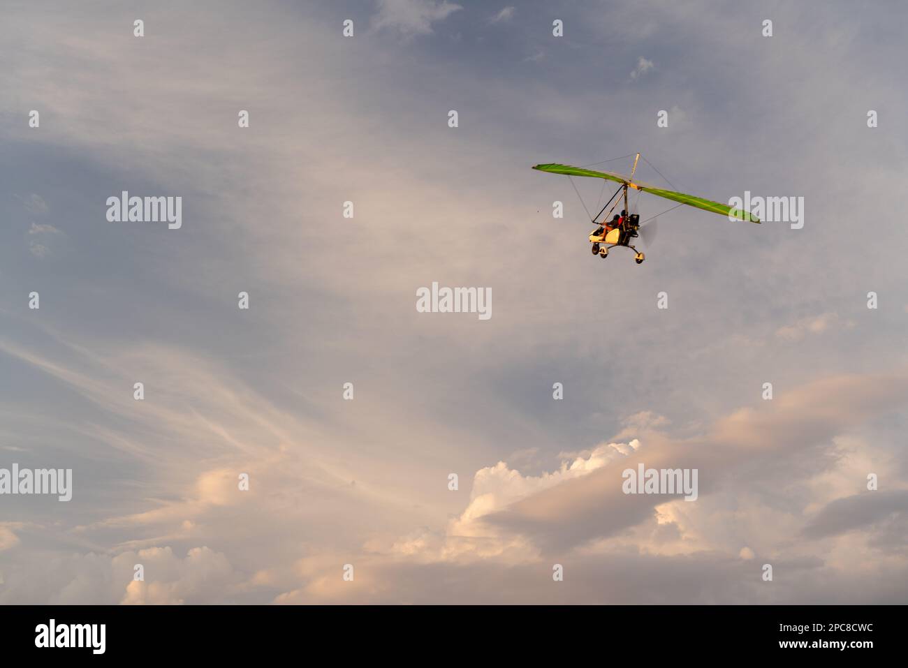 Propeller plane flies in the sunset sky. A small private hang-glider in ...