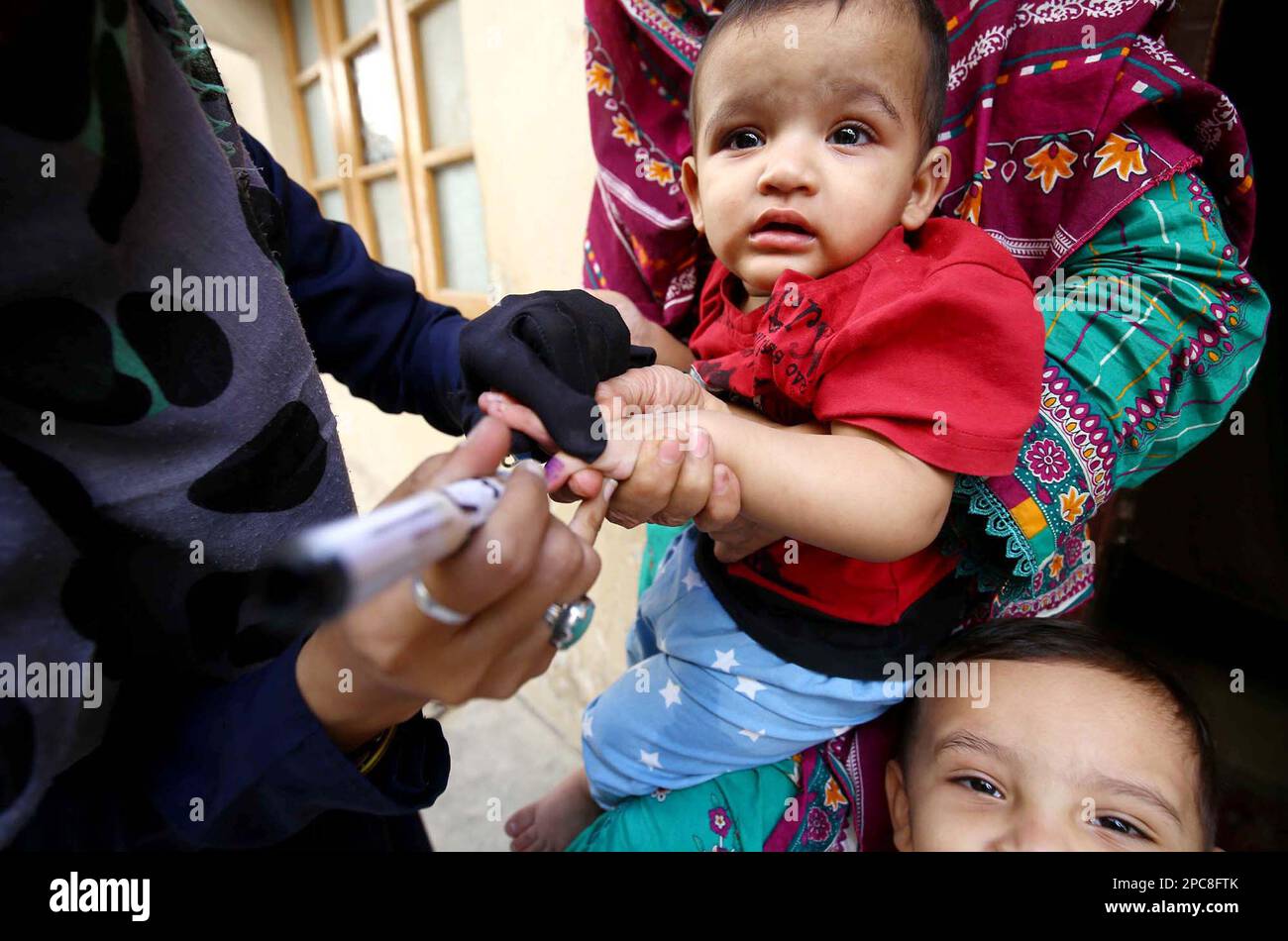 Health worker administrates polio-vaccine drops to a child during anti ...