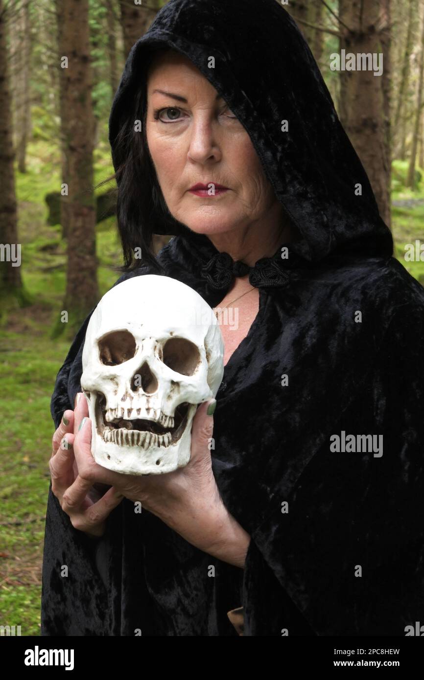Mature female witch with a human skull - John Gollop Stock Photo - Alamy