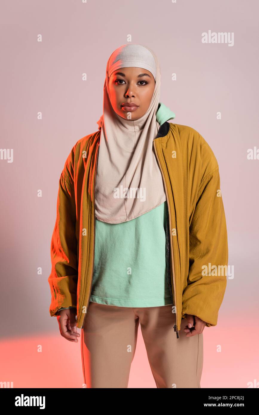 young multiracial muslim woman in yellow bomber jacket and hijab ...