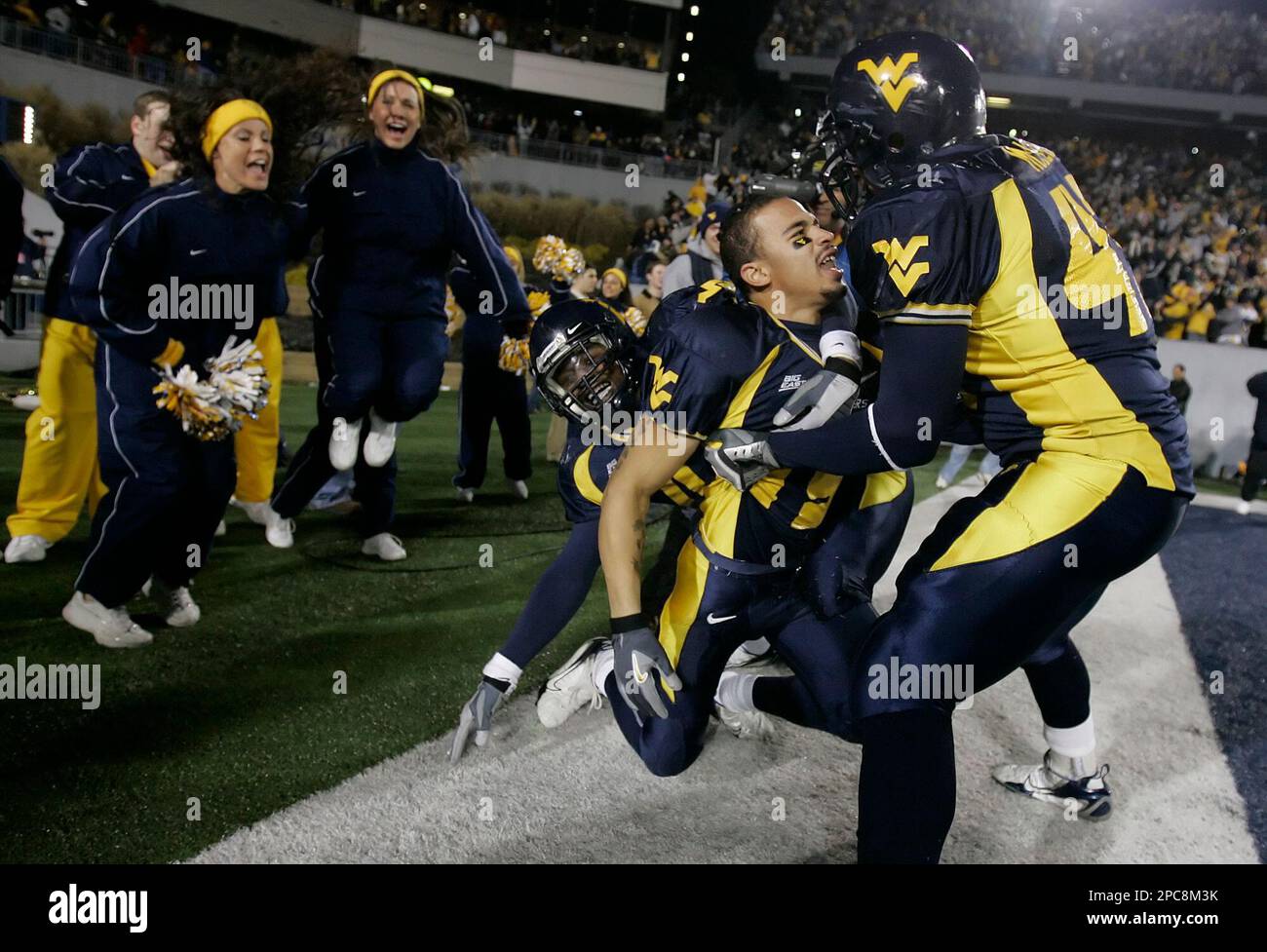 West Virginia defender Quinton Andrews, center, is helped up by ...
