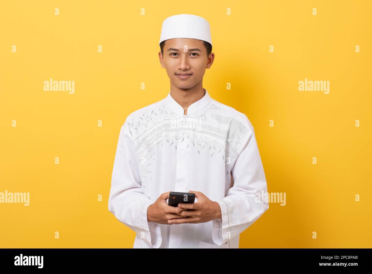Young handsome asian muslim man smiling using smartphone standing over ...