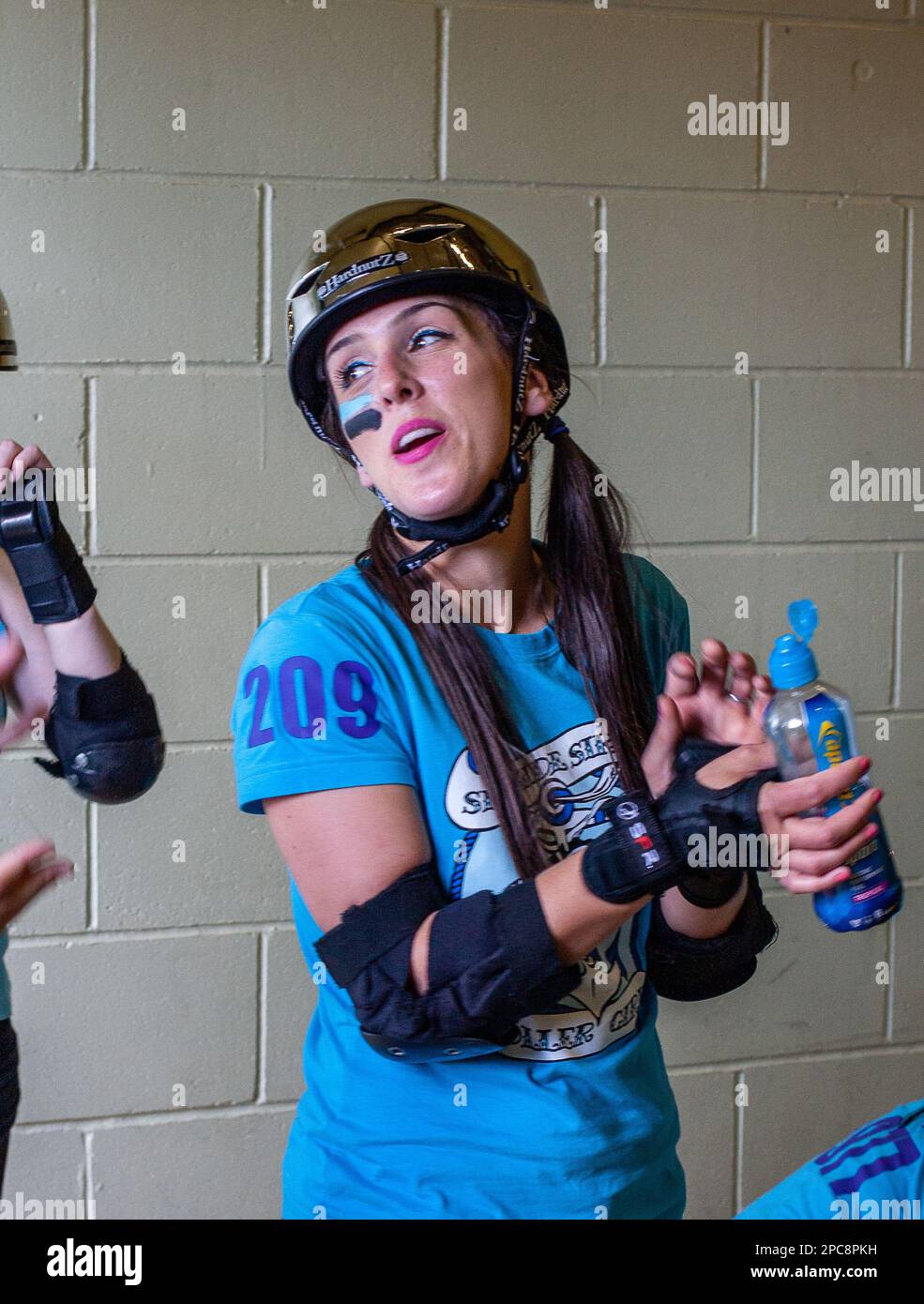 Seaside Siren roller derby skater claps whilst holding a soft drink ...