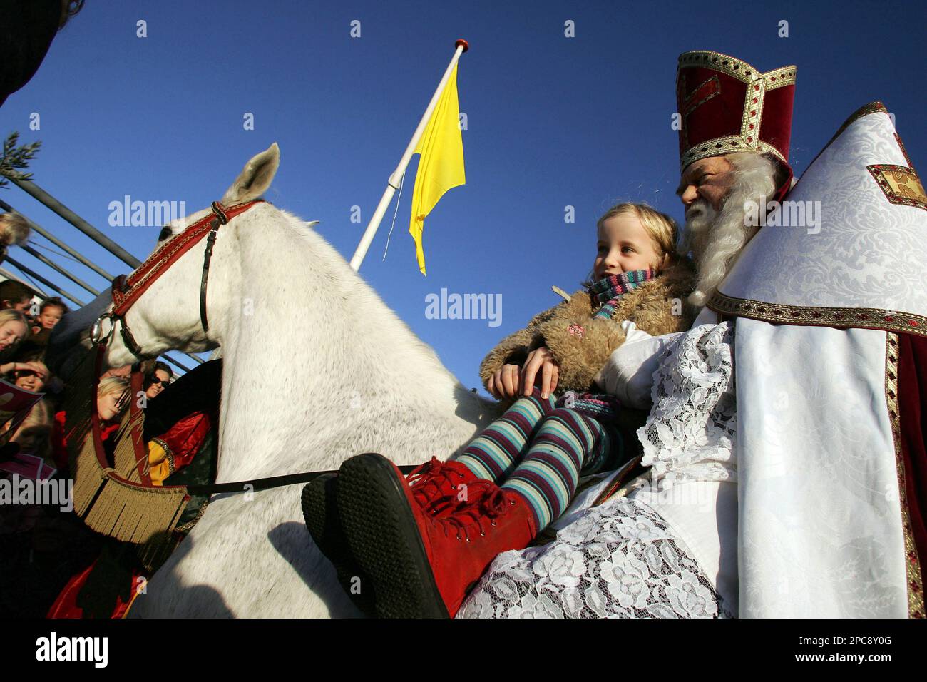 Sinterklaas, the Dutch equivalent of Santa Claus, holds a child on his ...