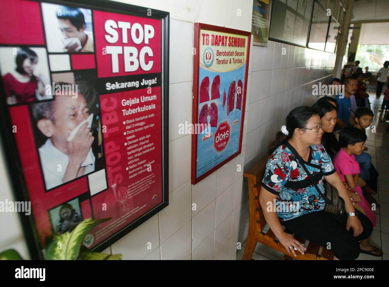 Patients sit near an anti-Tuberculosis (TB) campaign poster at a ...