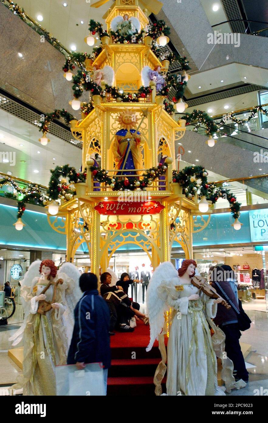 Passersby view a Christmas-themed golden tower flanked by two angels at ...