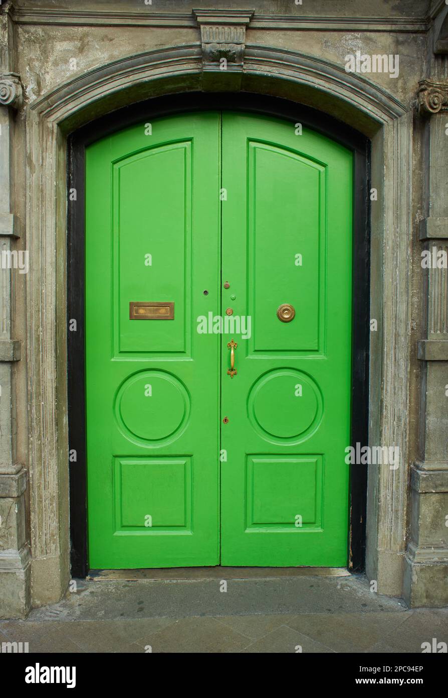 View of brightly colored traditional English green house door. Entrance ...