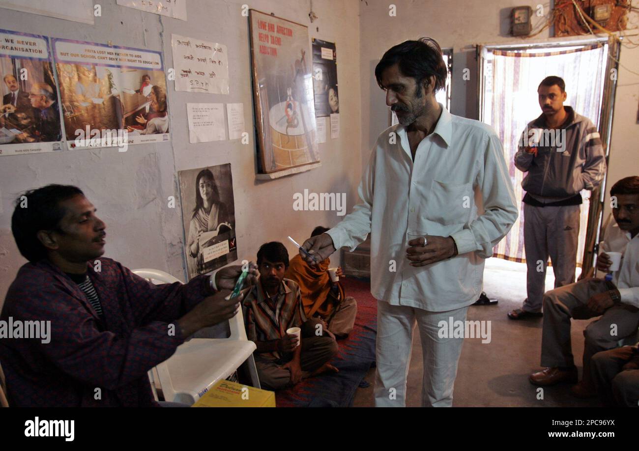 Tek Chand, left, a peer leader, hands out a new syringe to a drug ...