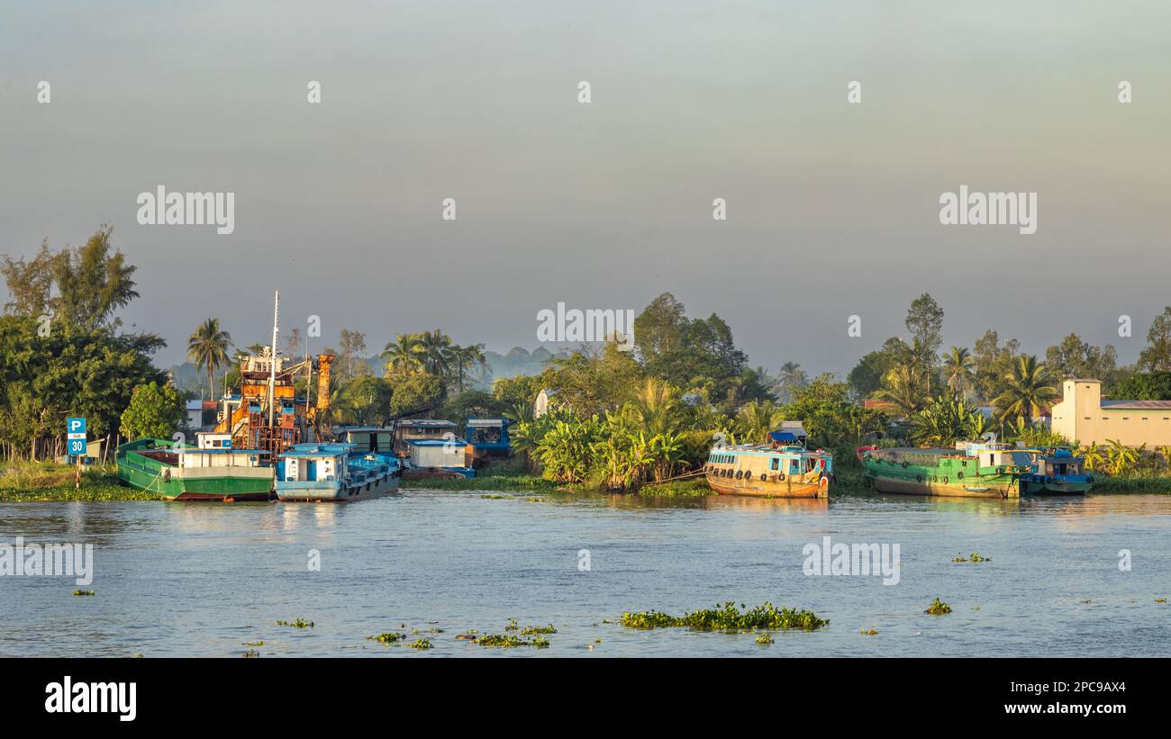 Boats and motorised barges lie pulled up on the banks of the Mekong ...