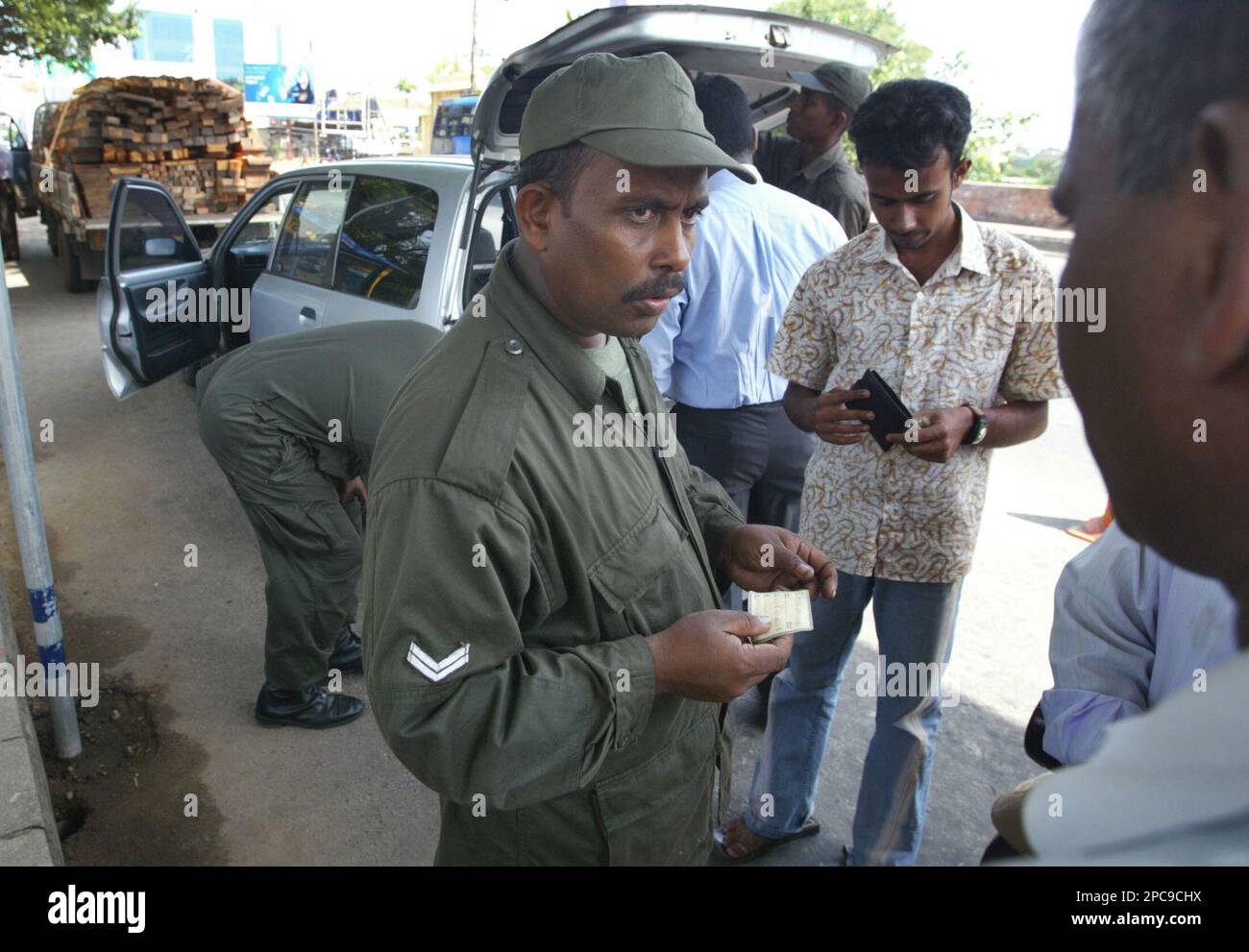 A Sri Lankan army soldier checks the identity of a civilian at a checkpoint in Colombo, Sri ...