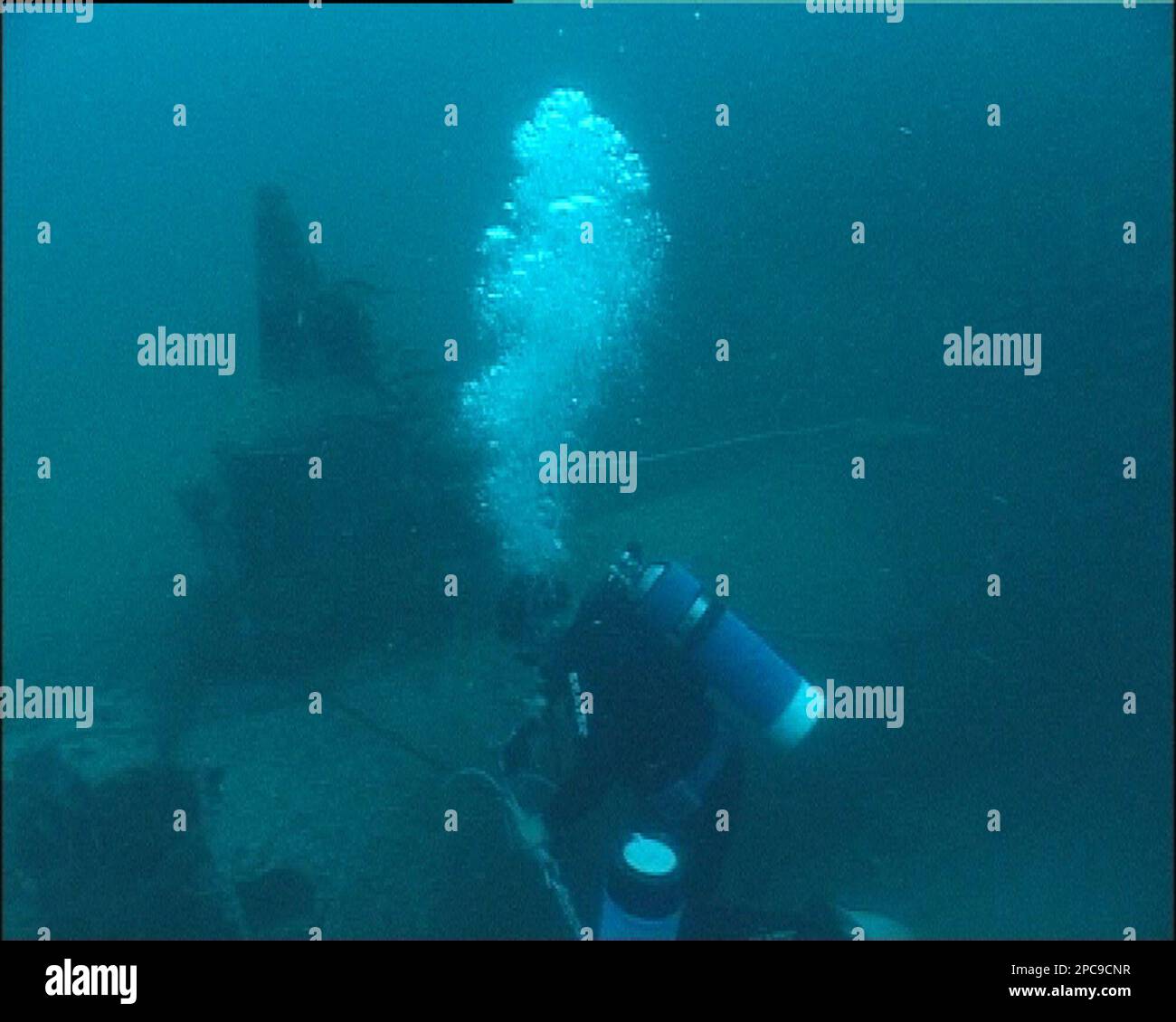A diver inspects the wreck of what is believed to be a Japanese ...