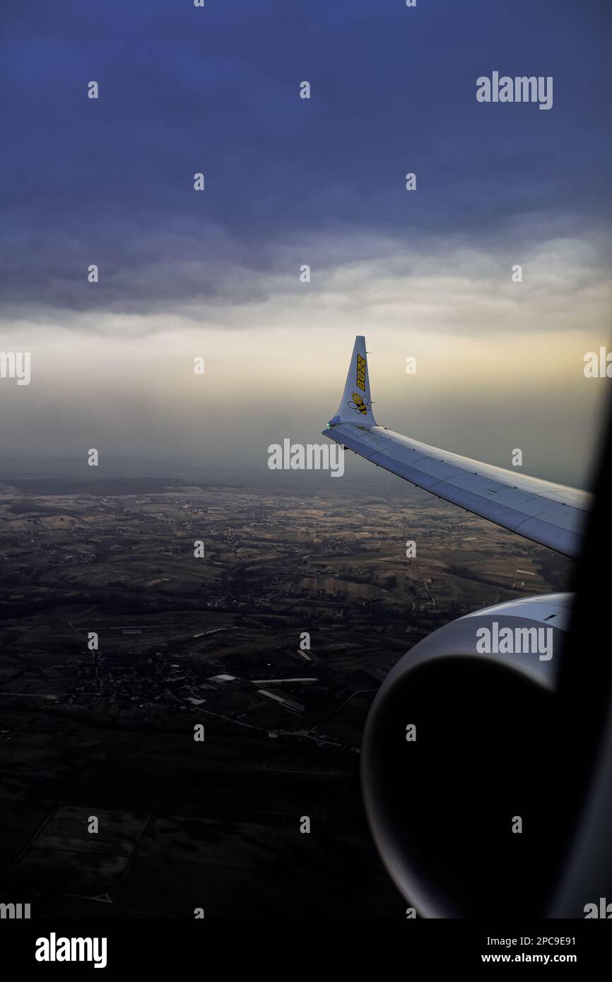 Airplane wing in the sky, plane above clouds mountains and cities ...