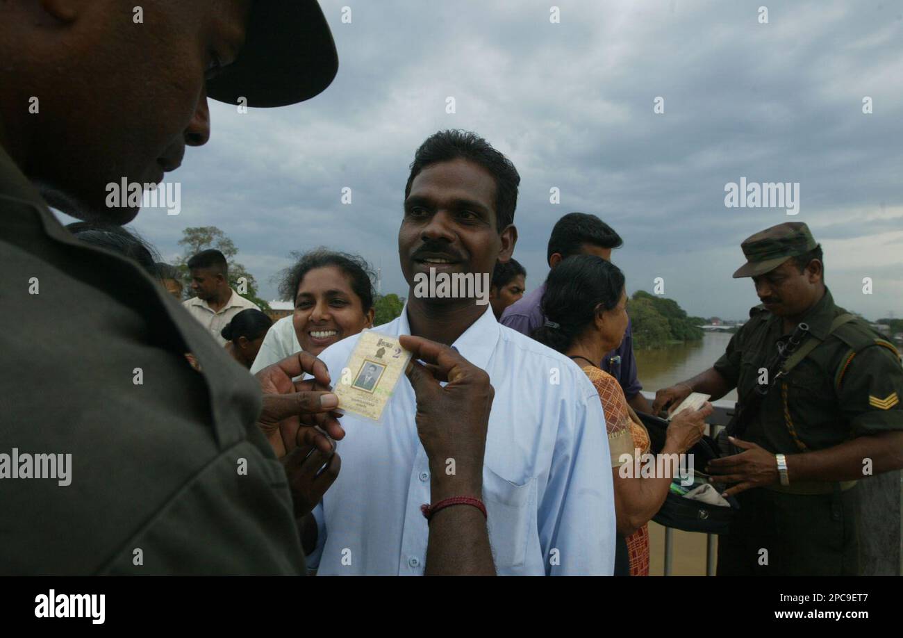 Sri Lankan government soldiers inspect the identity of commuters at a check point in Colombo ...