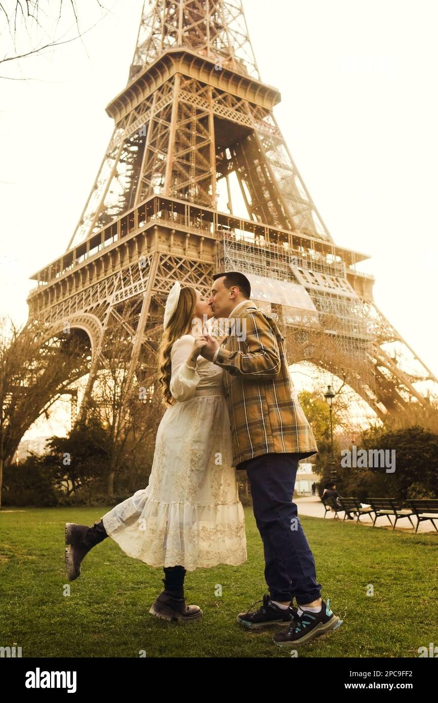 A couple kissing in front of the Eiffel Tower in Paris. Romantic trip ...