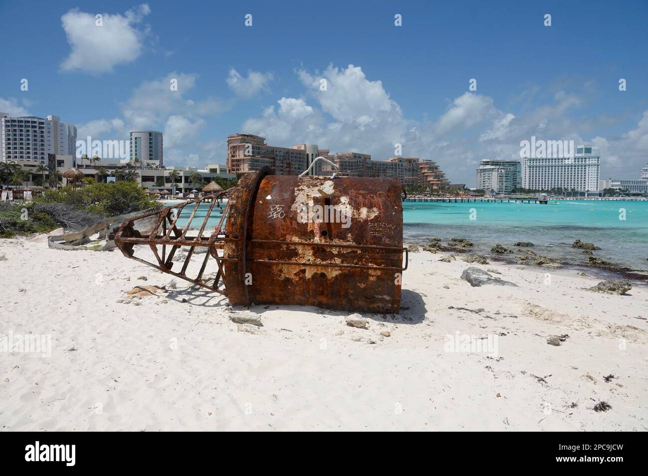 A large iron rust buoy on a sandy beach by the sea in Cancun, Mexico ...