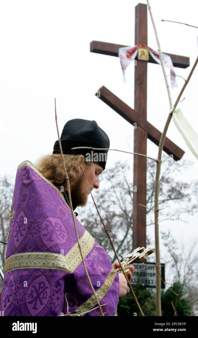 Orthodox priest stands at the monument to Soviet-era famine victims ...