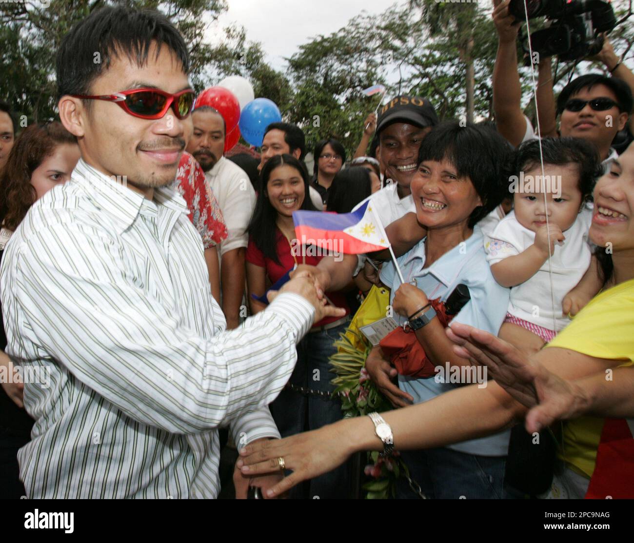 Philippine boxing great Manny "Pacman" Pacquiao, left, is mobbed by a ...