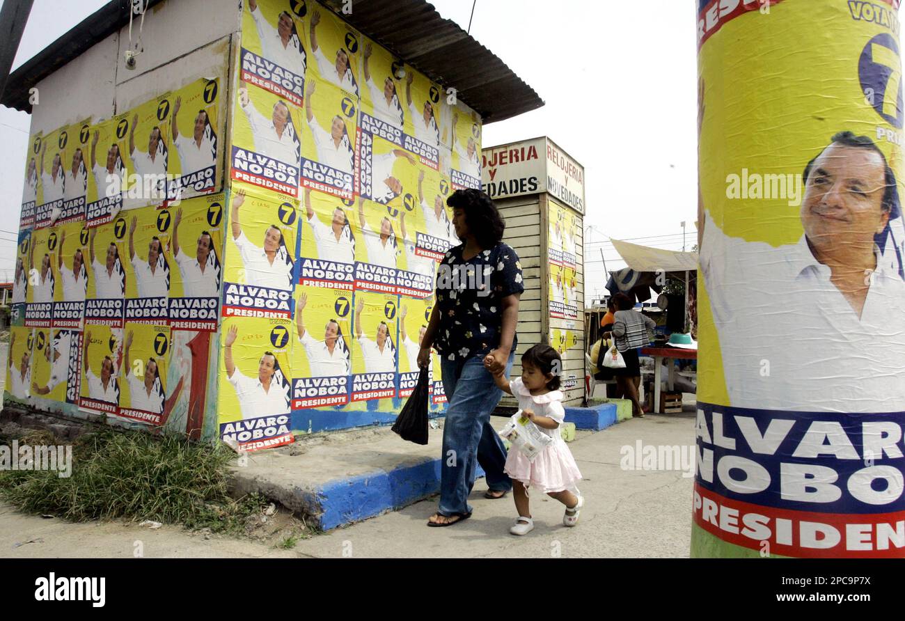 A woman walks by elections posters of Ecuador's presidential candidate ...