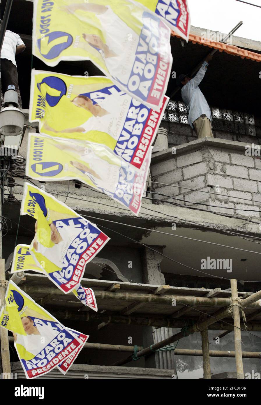 A man works beside election posters of Ecuador's presidential candidate Alvaro Noboa in Recreo ...
