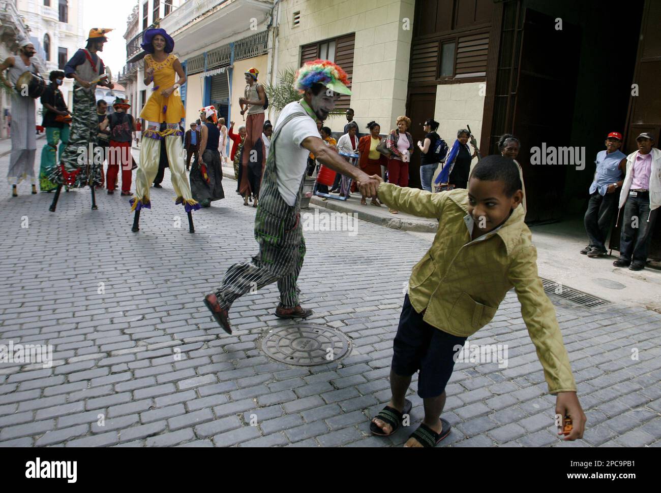 A clown of the "Giganterias" group plays with a boy in a street in Old ...