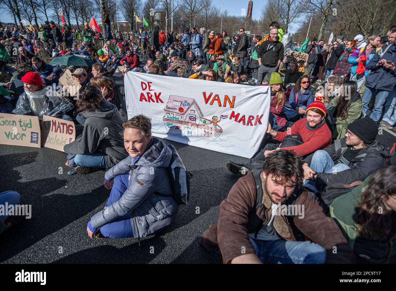 Activists sit-down while holding placards and a banner during the ...
