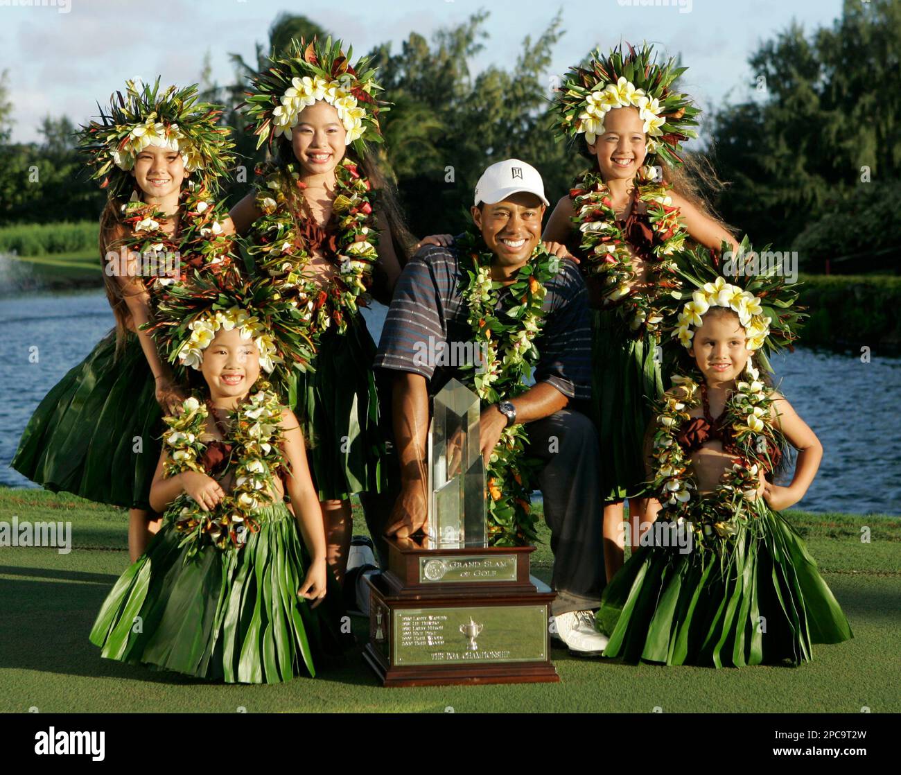 Tiger Woods poses with the trophy and hula dancers after winning the ...