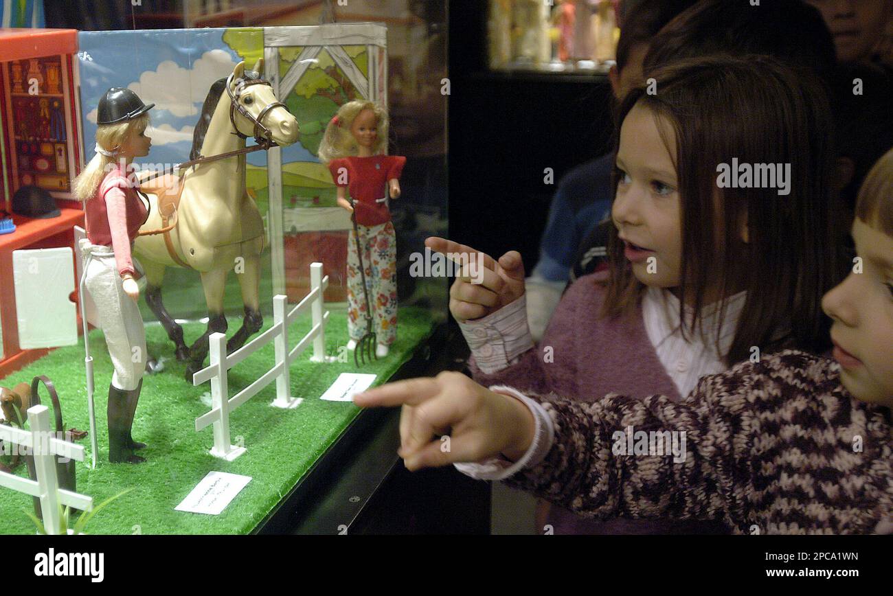 Young Polish girls look at Barbie dolls at an exhibition of more than ...