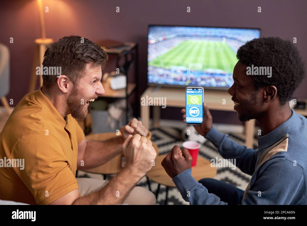 Side view portrait of two emotional football fans watching match at ...
