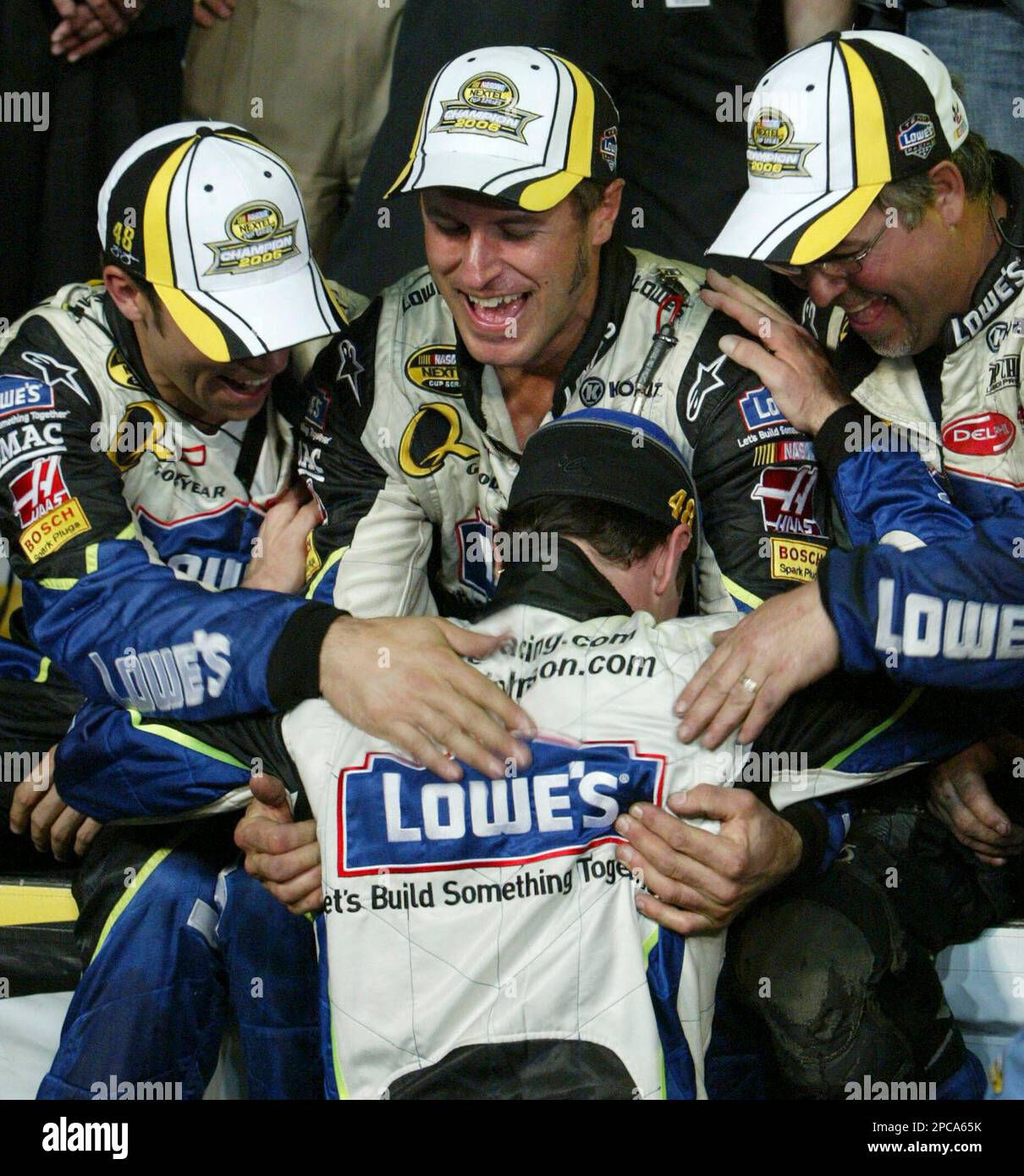Driver Jimmie Johnson is hugged by members of his pit crew after ...