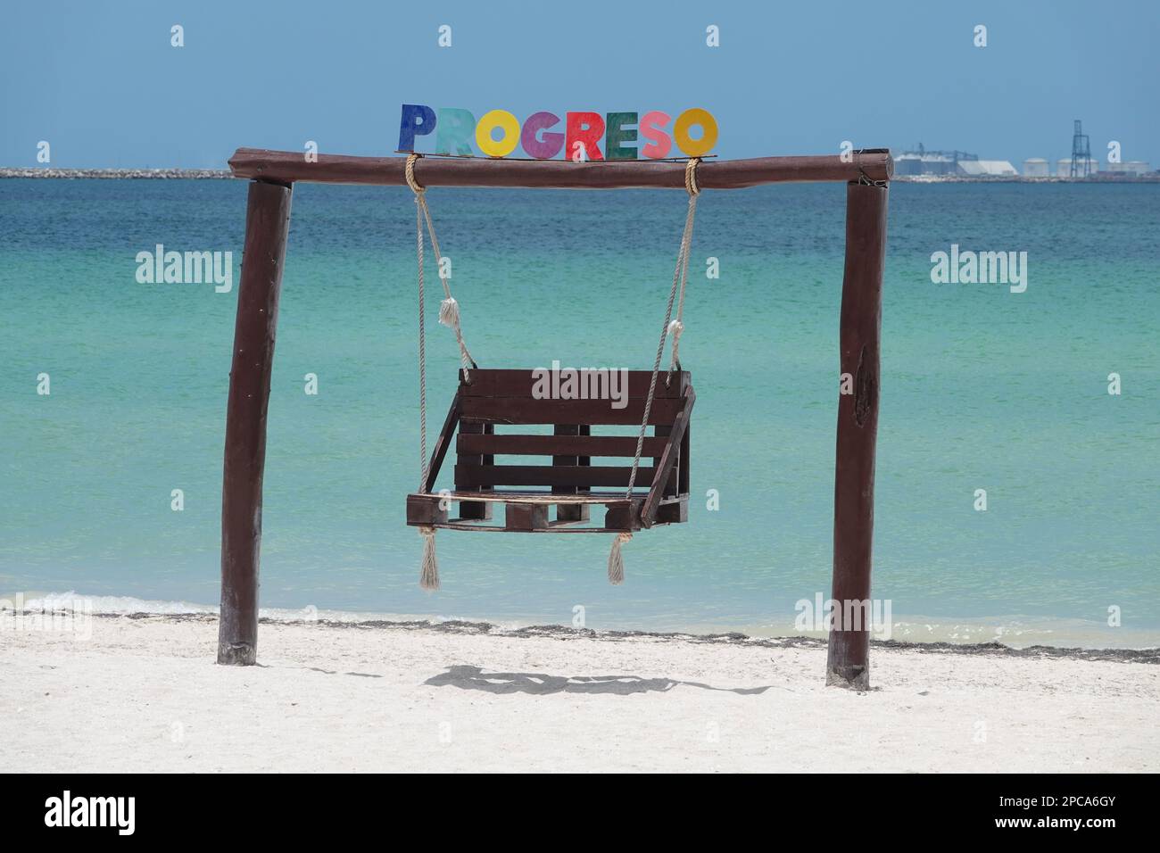 View of swing made of wood with colorful sign on the beach of progreso ...