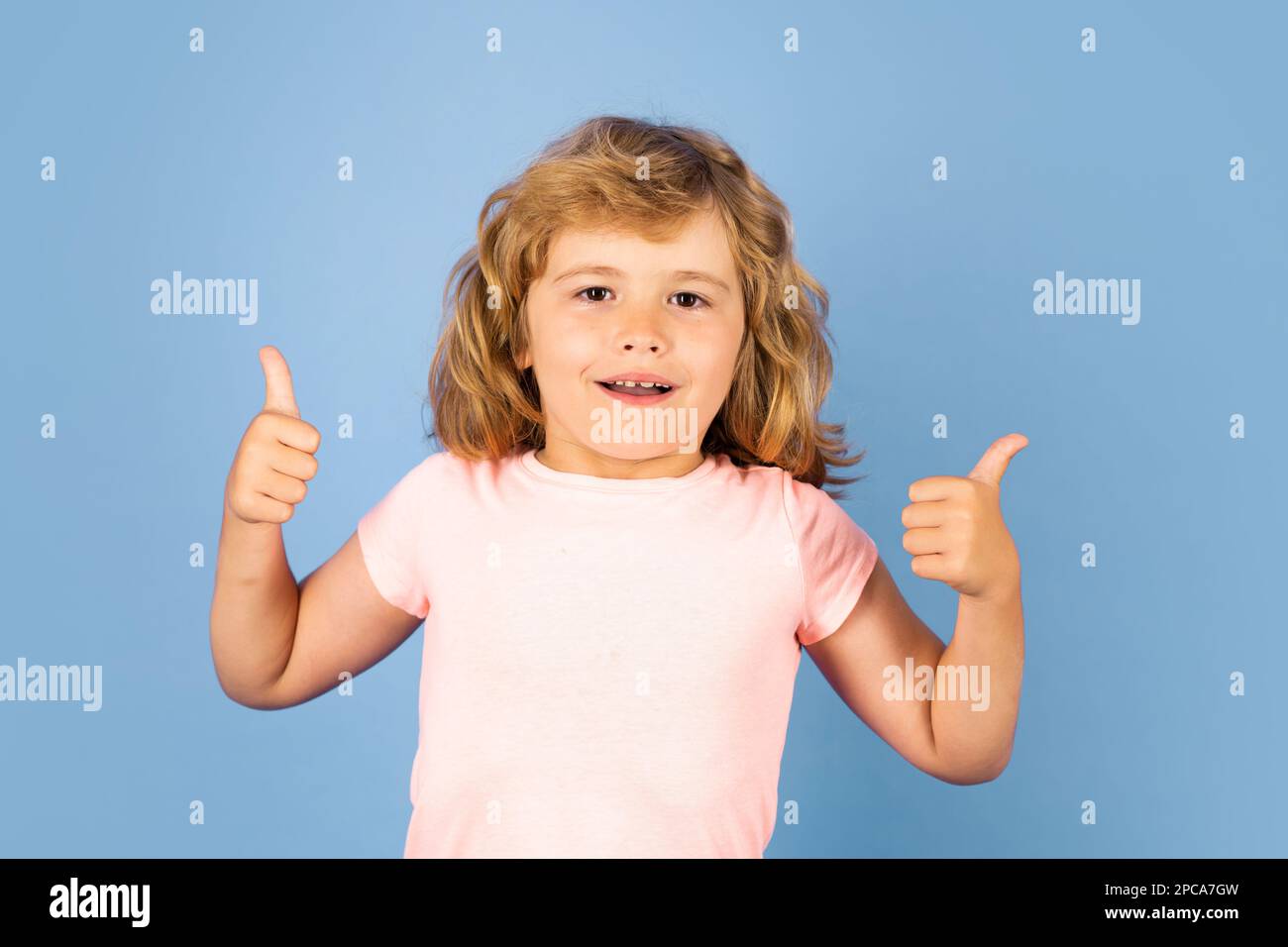 Child showing thumbs up on studio isolated background. Portrait of kid ...