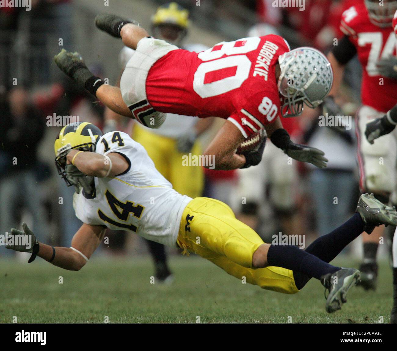 Ohio State's Brian Robiskie (80) is upended by Michigan's Tyrone Jordan ...