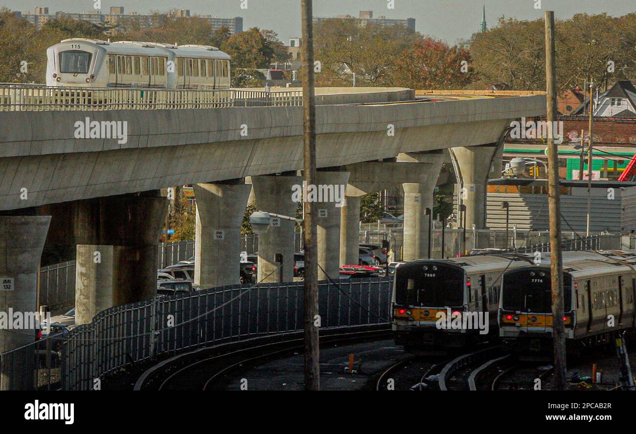 FILE - The JFK airport Airtrain, left, travels on overhead tracks above ...