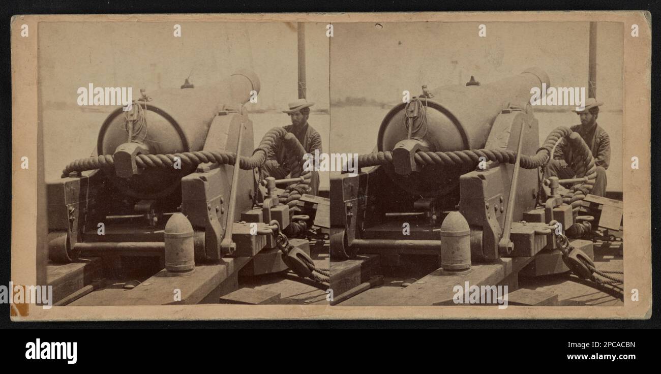 Rear view of a cannon with a soldier sitting adjacent to it facing ...