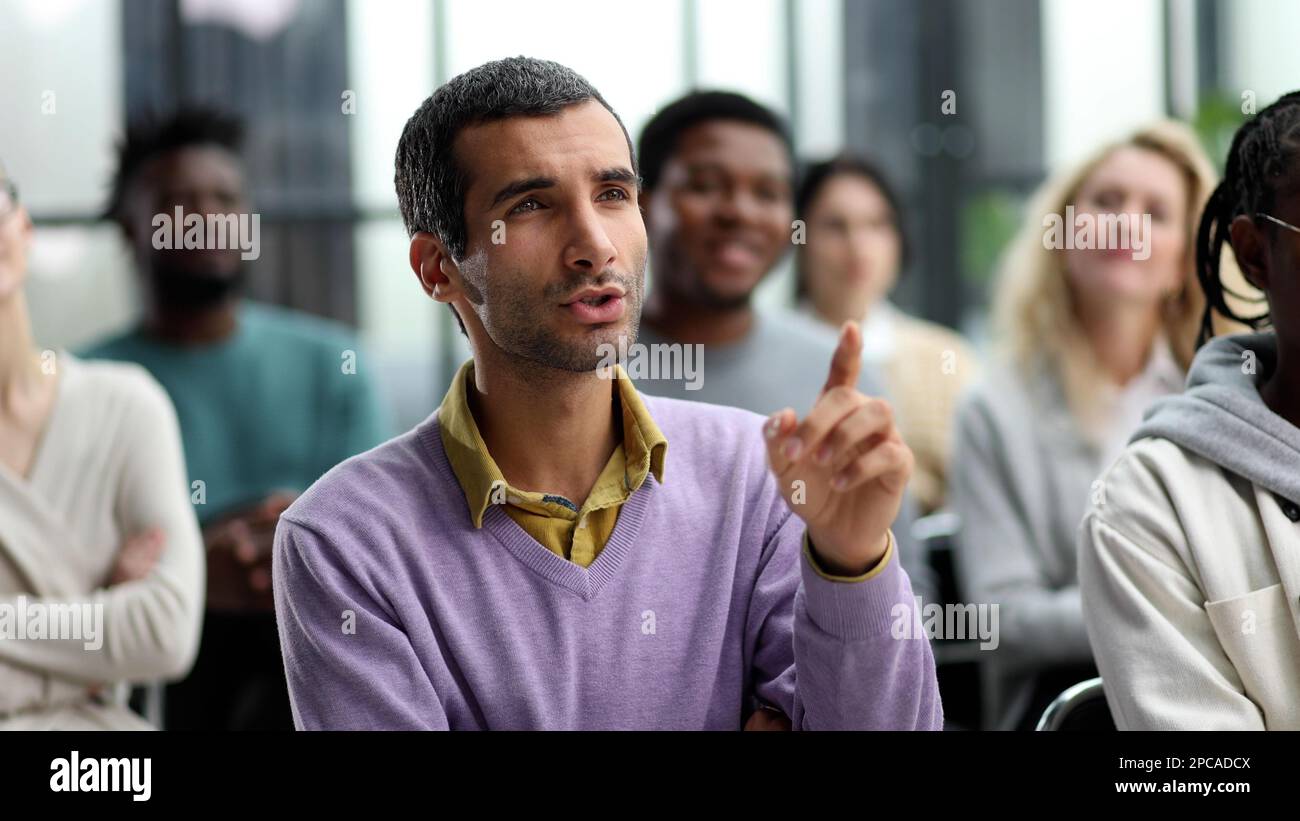 He got some questions. Group of young people sitting on conference ...