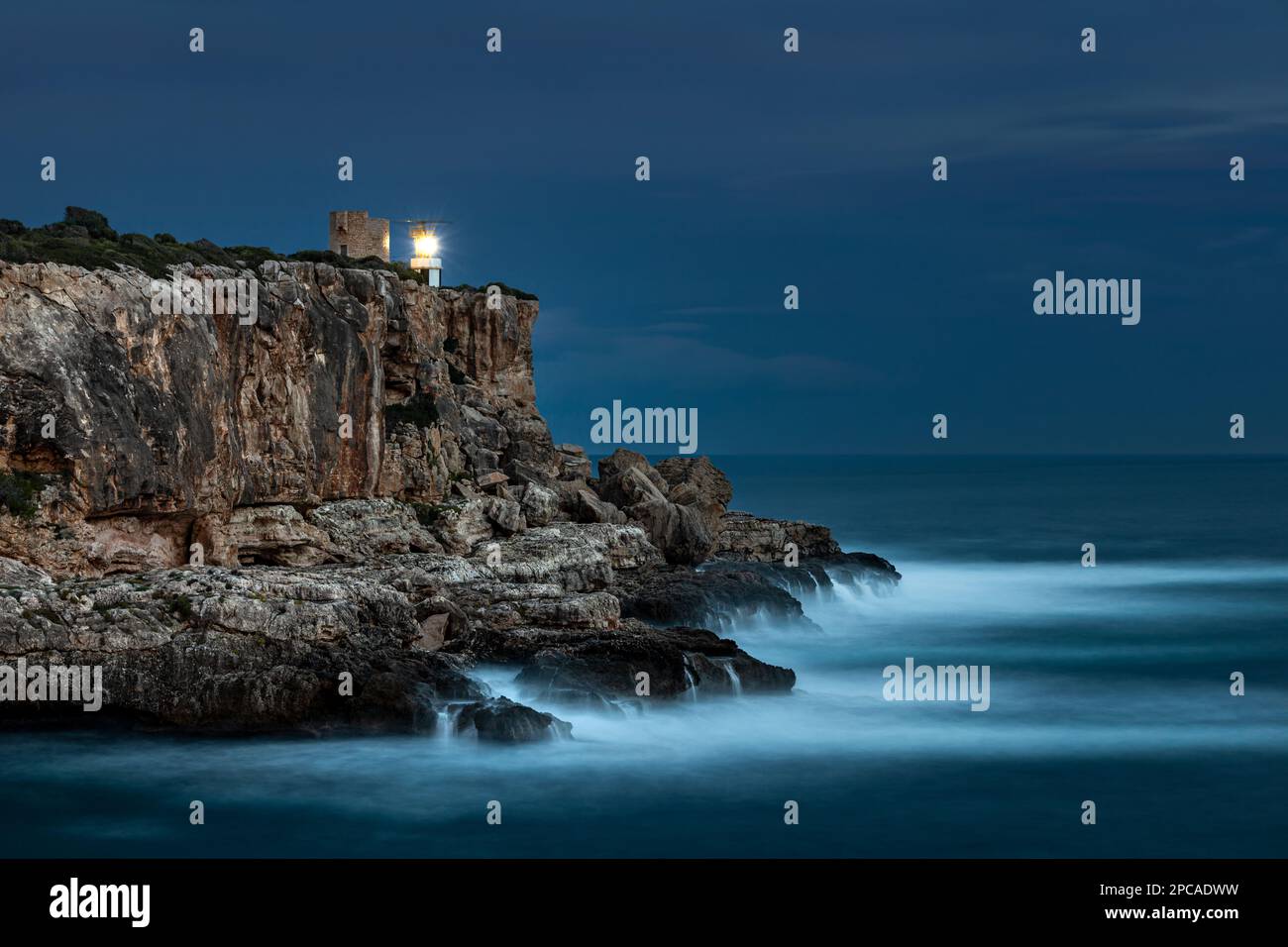 Rocky cliff with old watchtower and radar station at night in Cala ...