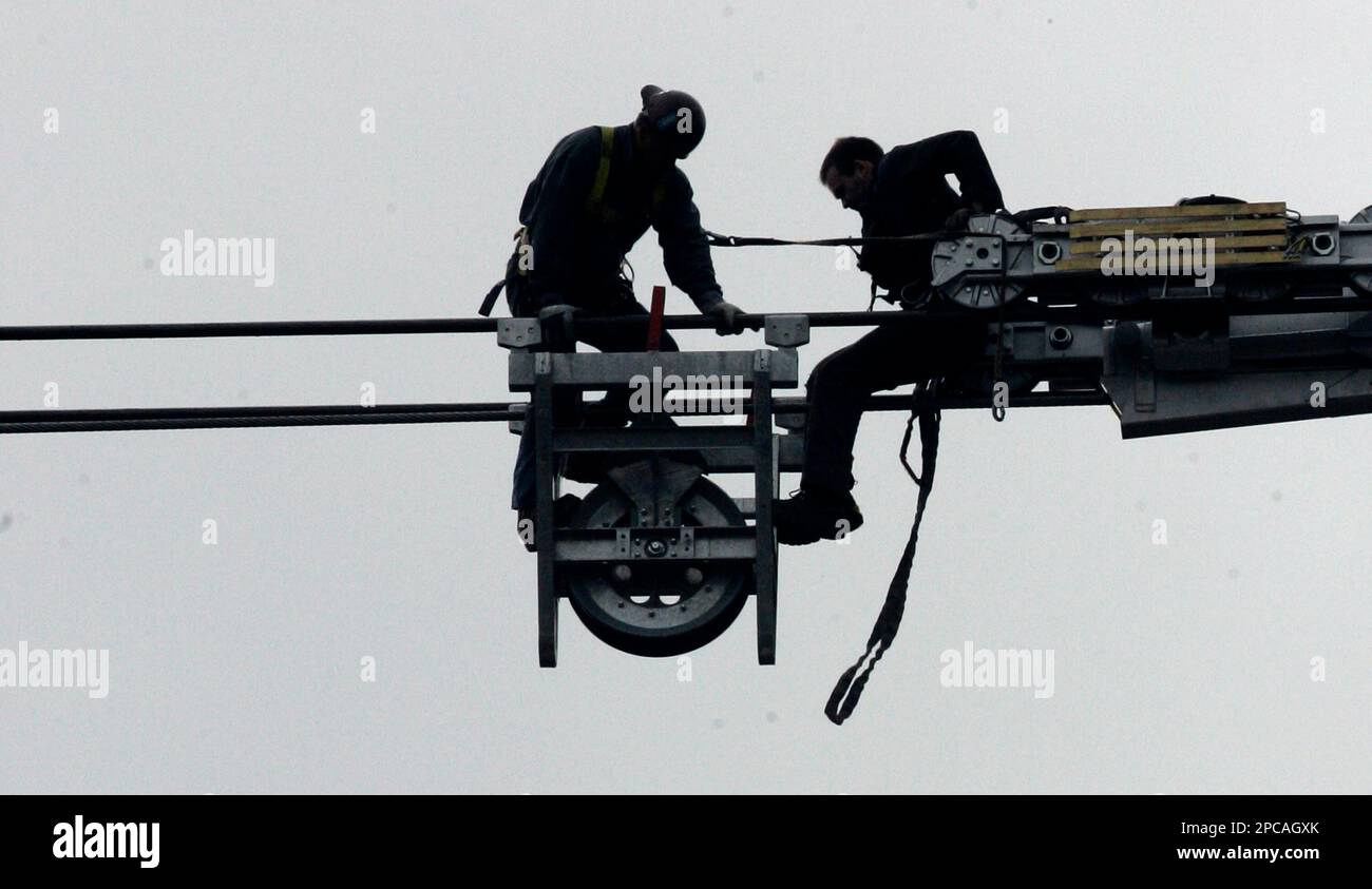 Maintenance workers work on top one of two aerial trams Thursday, Nov ...