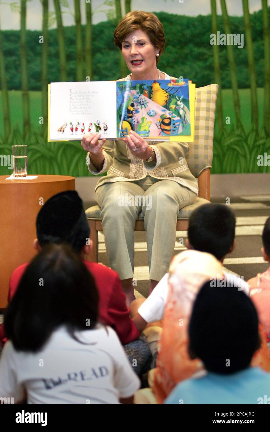 U.S. first lady Laura Bush shows pictures from a story book while ...
