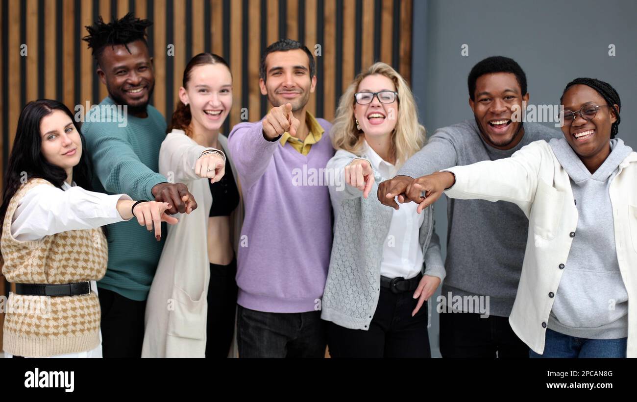 Group of cheerful young people standing close to each other and ...