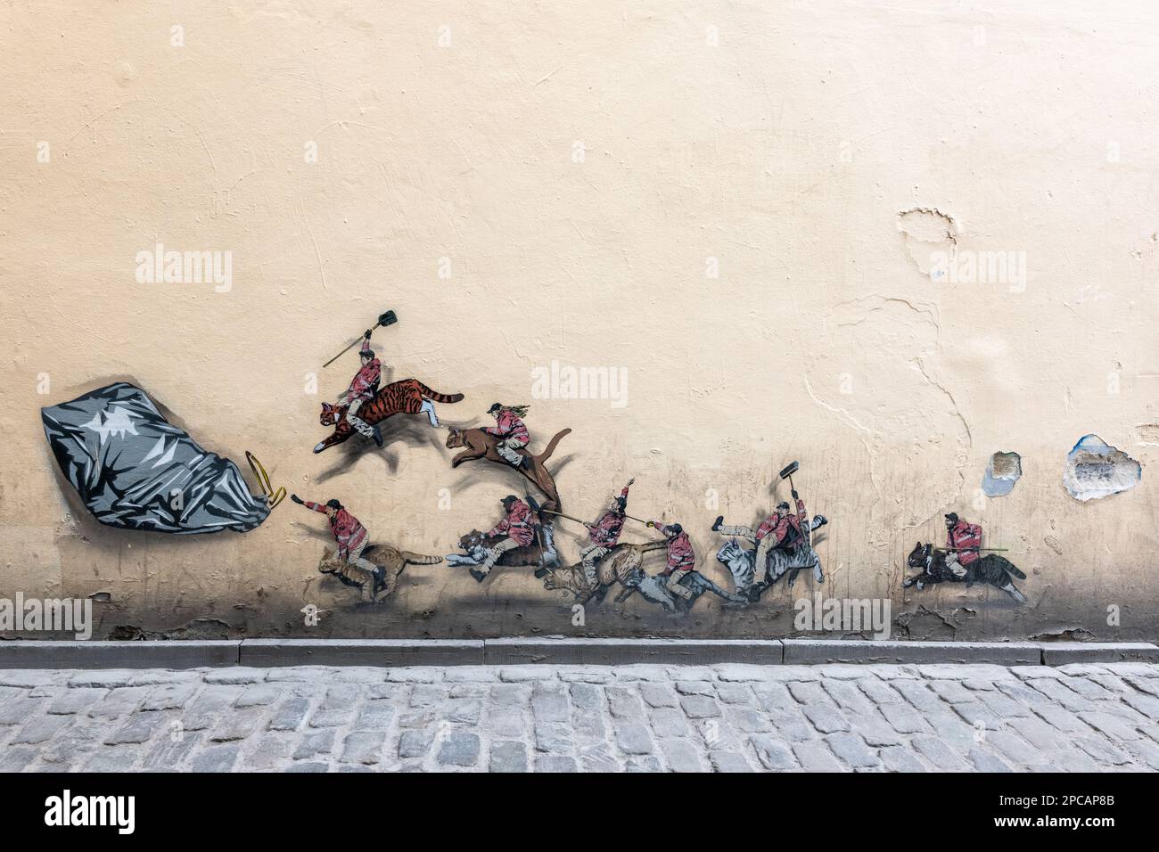 Banksy style graphics on wall in Brussels of men in red coats on cats ...