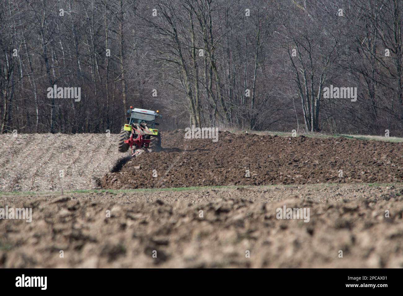 Tractor working the land in the fields. Farmer preparing land for ...