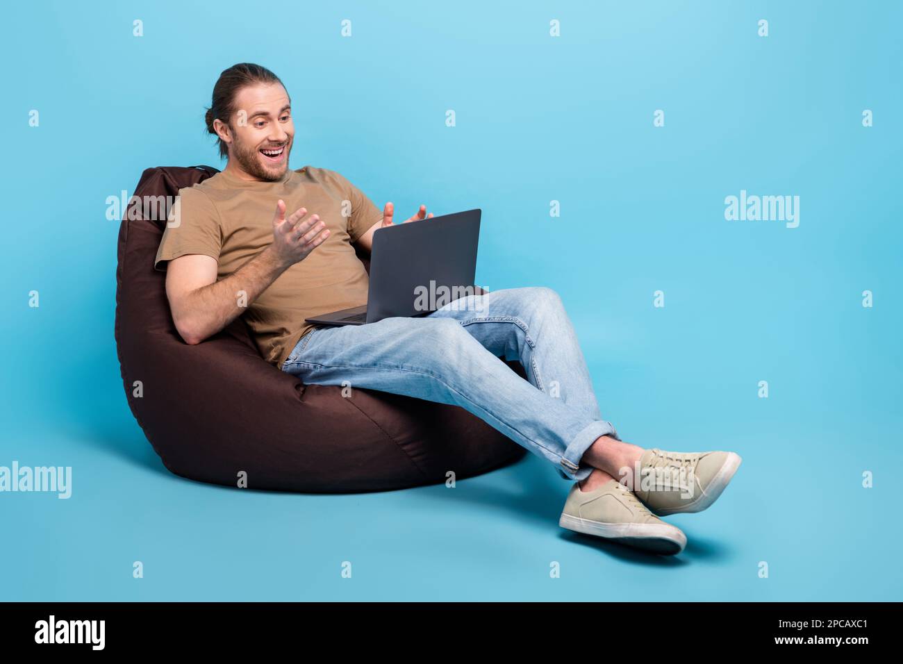 Full length photo of positive cute man wear beige t-shirt bean bag ...