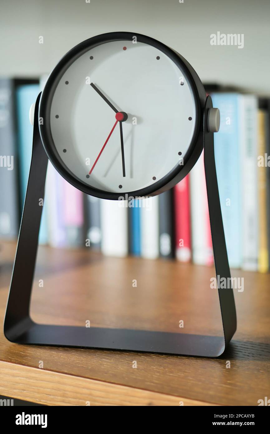 simple modern clock on a book shelf Stock Photo - Alamy